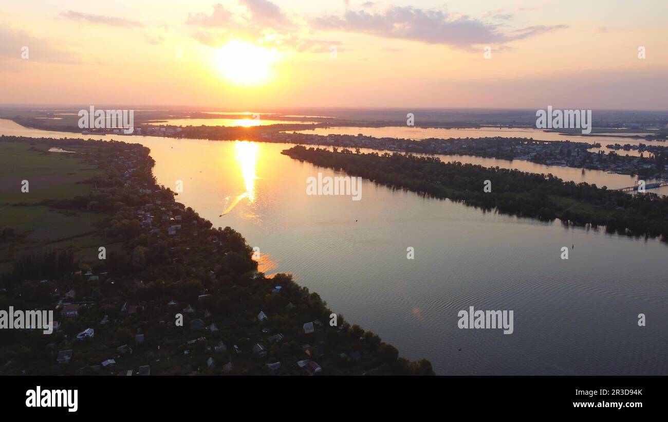 Drone fly over waving river surrounded by local village with various ...