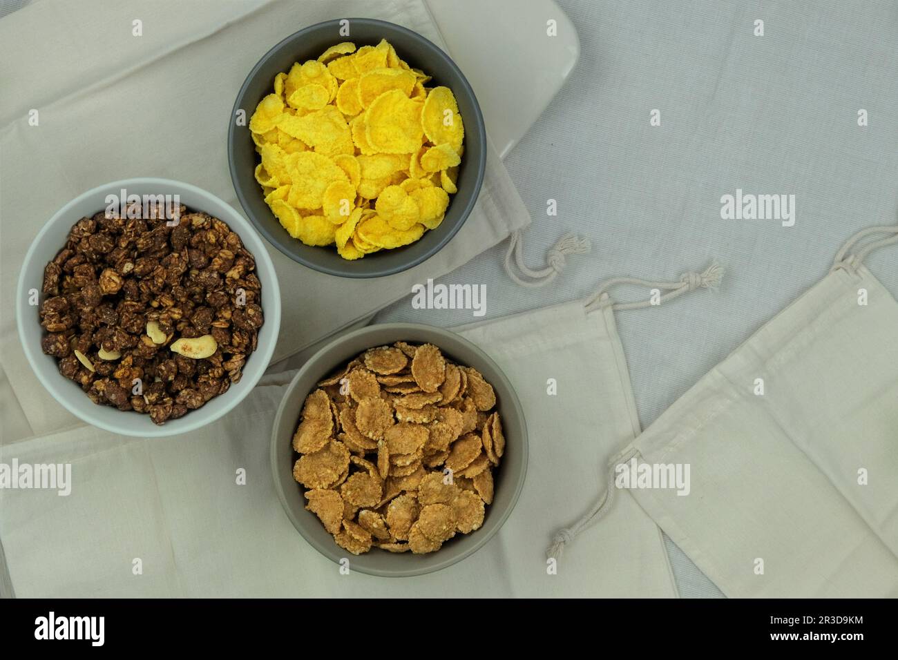 Variety of breakfast cereals and muesli in bowls on a light wooden ...