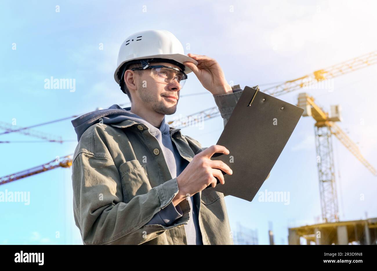 Civil engineer or architect on construction site checking schedule with ...