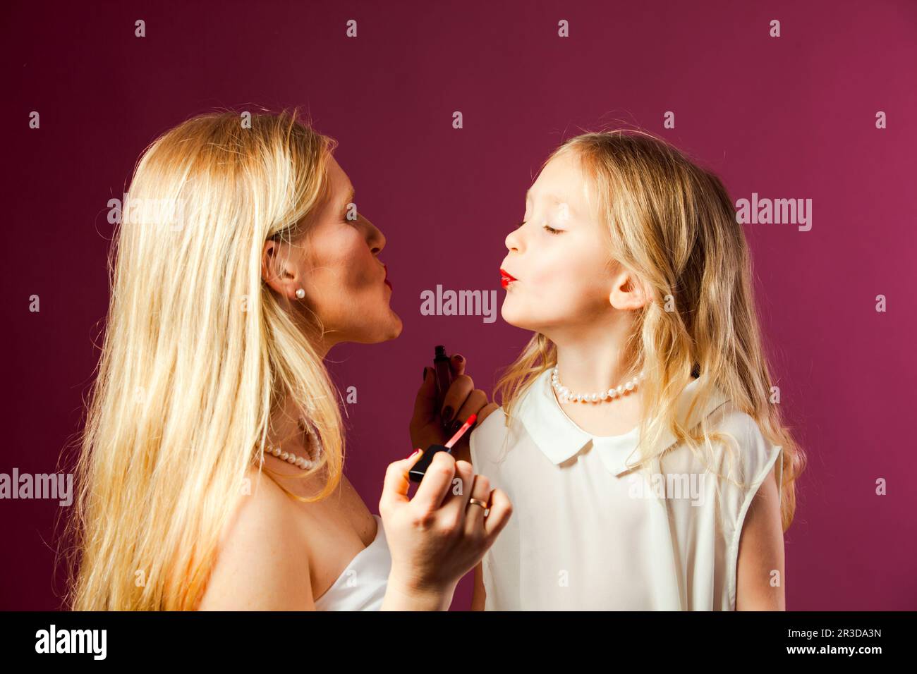 Close-up mother colouring lips of her daughter Stock Photo - Alamy