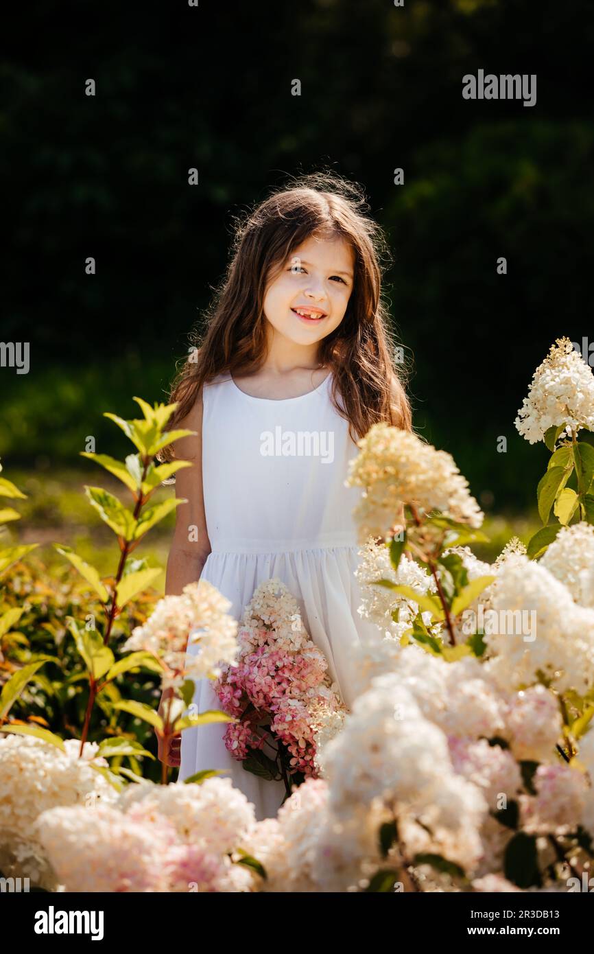 Little girls dancing among wonderful blooming flowers Stock Photo - Alamy