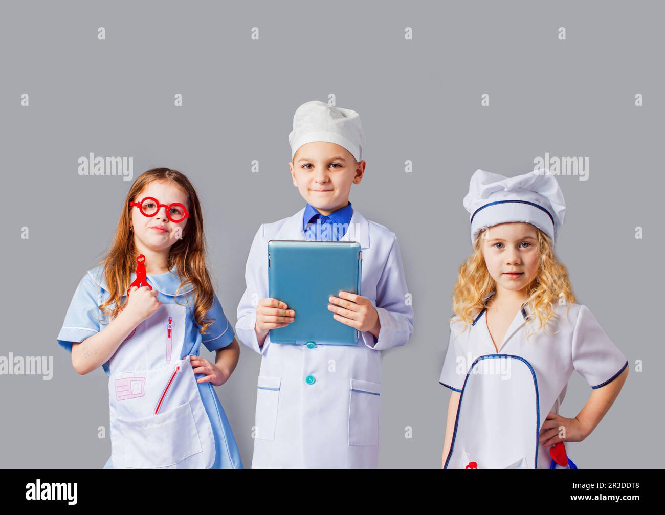 Cute little children dressed as doctors on grey Stock Photo - Alamy