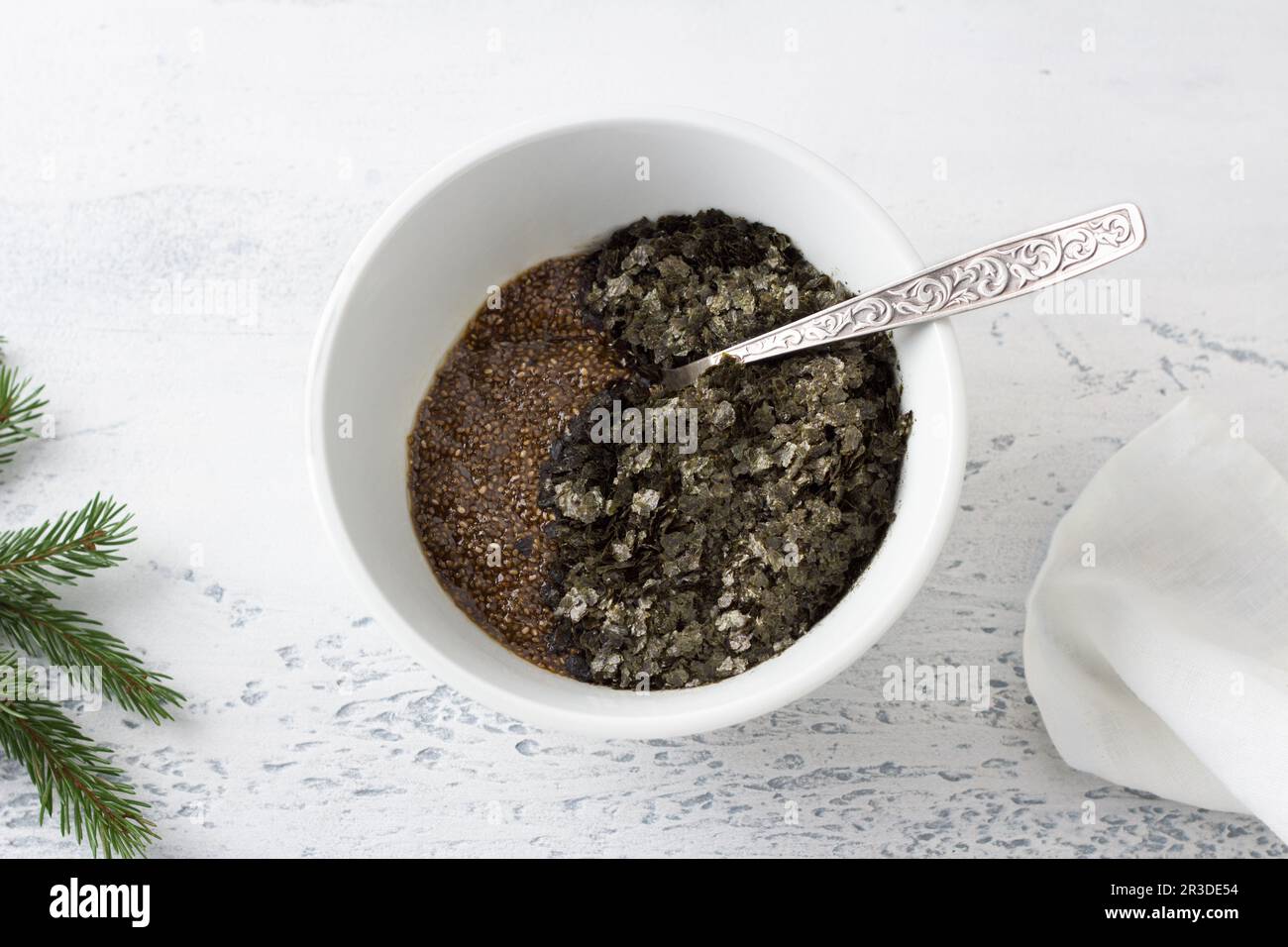 White ceramic bowl with soaked chia seeds, soy sauce, linseed oil and ...