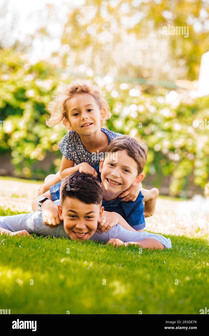 Portrait of three little children as a tower Stock Photo - Alamy