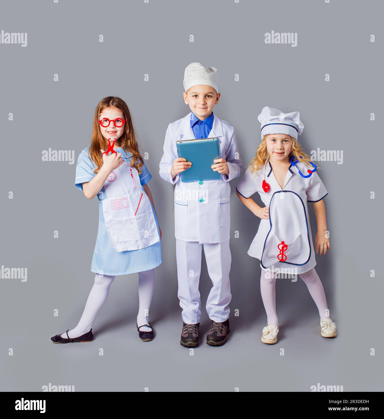 Cute little children dressed as doctors on grey Stock Photo - Alamy