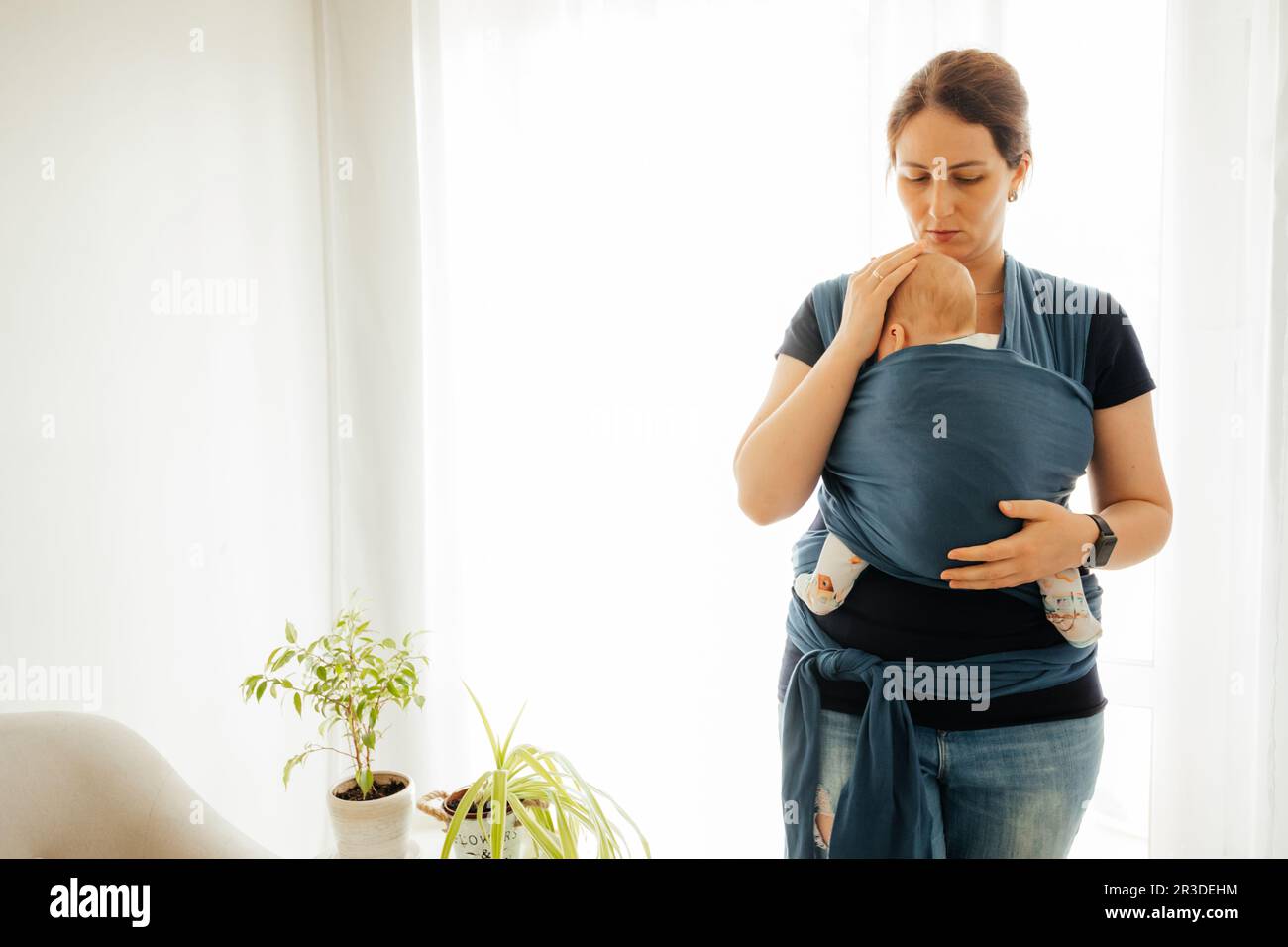 Attachment parenting concept. Young mother with baby in sling Stock ...