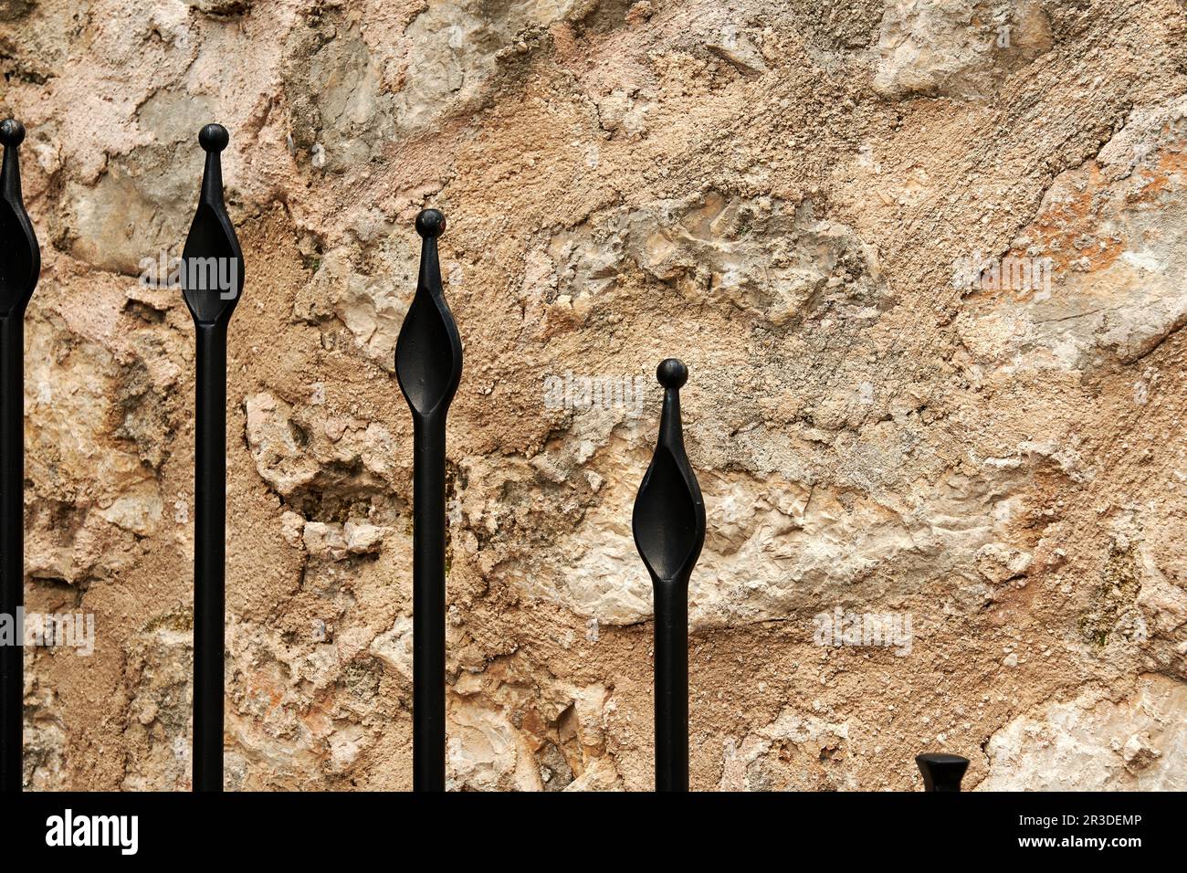 Abstract fence background with stone wall and metallic spears. Old ...