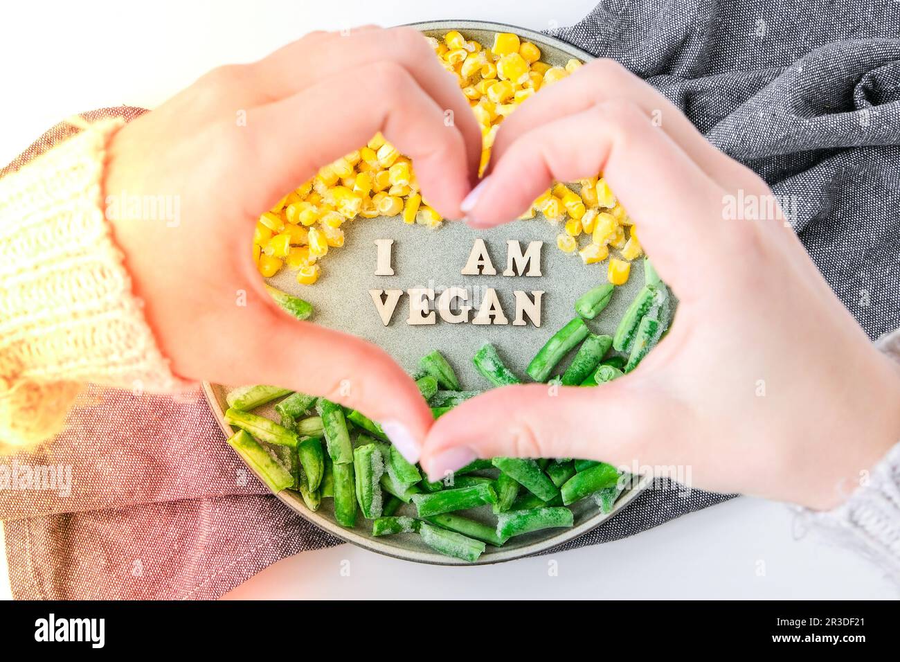 Female hands in shape of heart love I AM VEGAN text in plate. Veganism ...
