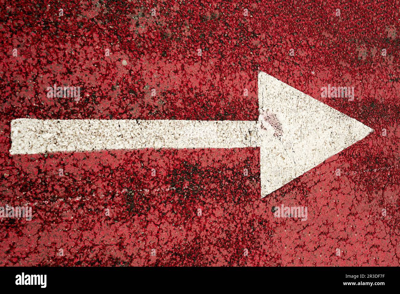 Red asphalt bike path with a white arrow symbol. City infrastructure ...