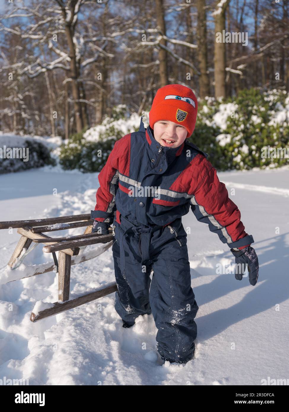 Boy is carrying sled Stock Photo - Alamy