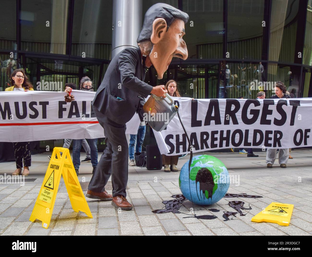 London, UK. 23rd May 2023. An activist wearing a Rishi Sunak mask pours ...