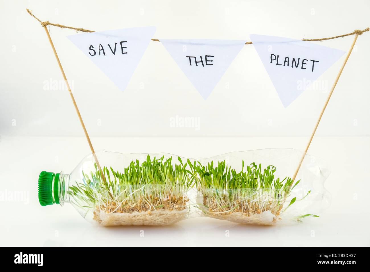 SAVE THE PLANET Young green plants in plastic bottle. Ecology and ...