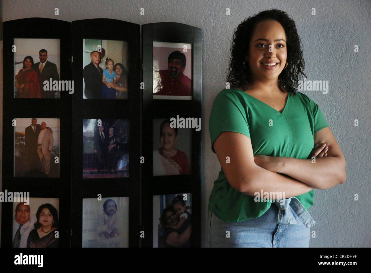 Avani Hamilton stands for a portrait next to family photos displayed in ...