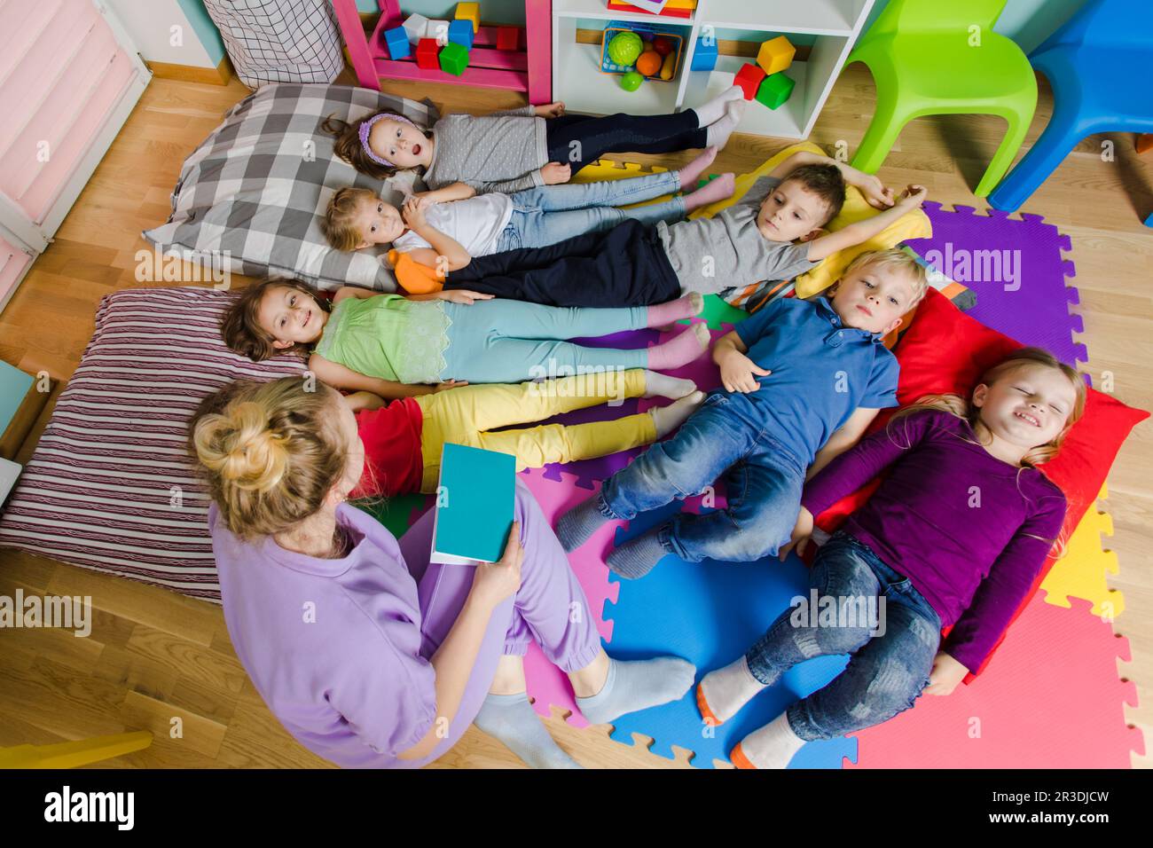 Active kids laying on soft pillows and mats at the kindergarten Stock ...