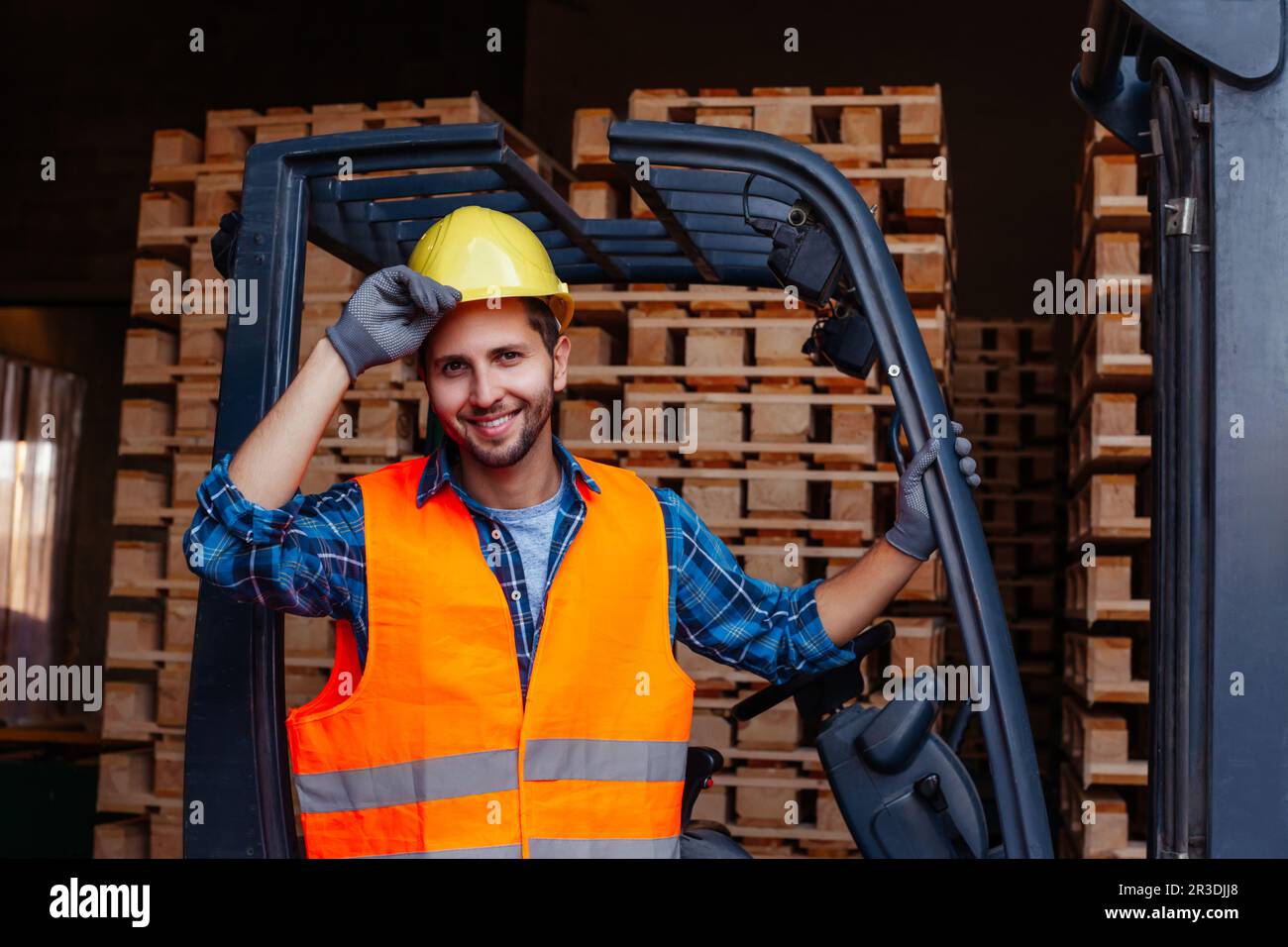 Smiling man posing near industrial stacker forklift at warehouse Stock ...