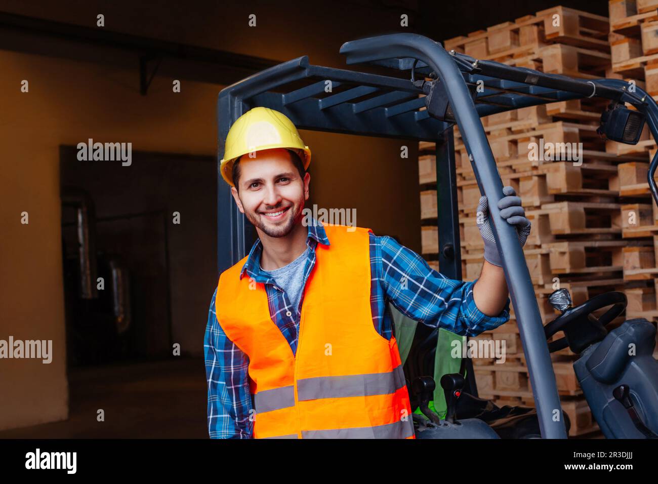 Smiling man posing near industrial stacker forklift at warehouse Stock ...