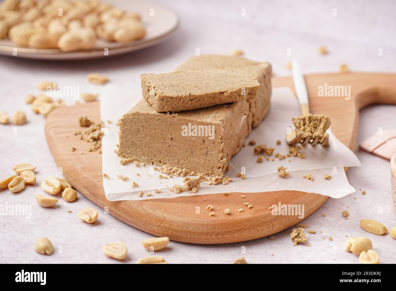 Board with tasty halva and peanuts on white background Stock Photo - Alamy
