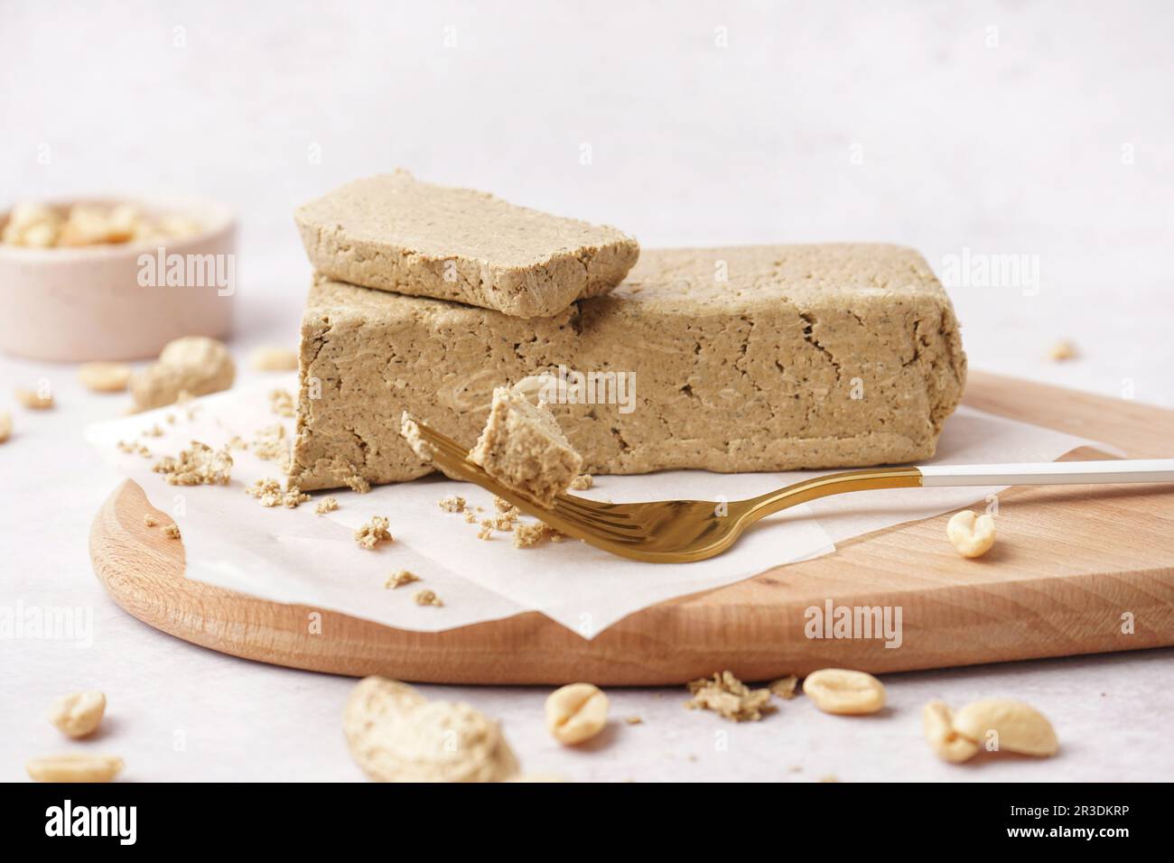 Board with tasty halva and peanuts on white background Stock Photo - Alamy