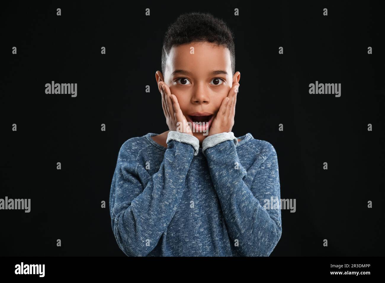 Scared little African-American boy on black background Stock Photo - Alamy