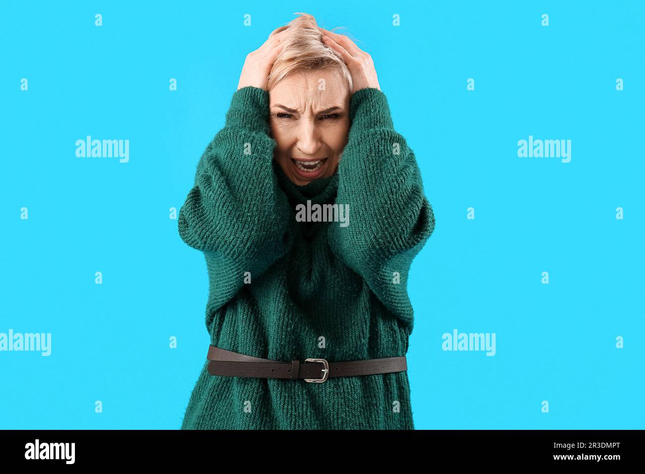 Scared mature woman on light blue background Stock Photo - Alamy