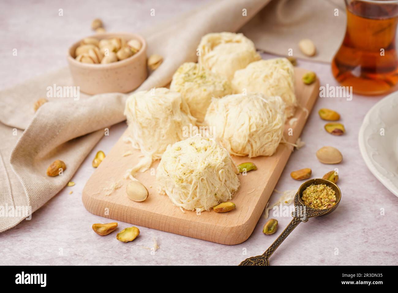 Wooden board with tasty Turkish Pismaniye on light background Stock ...