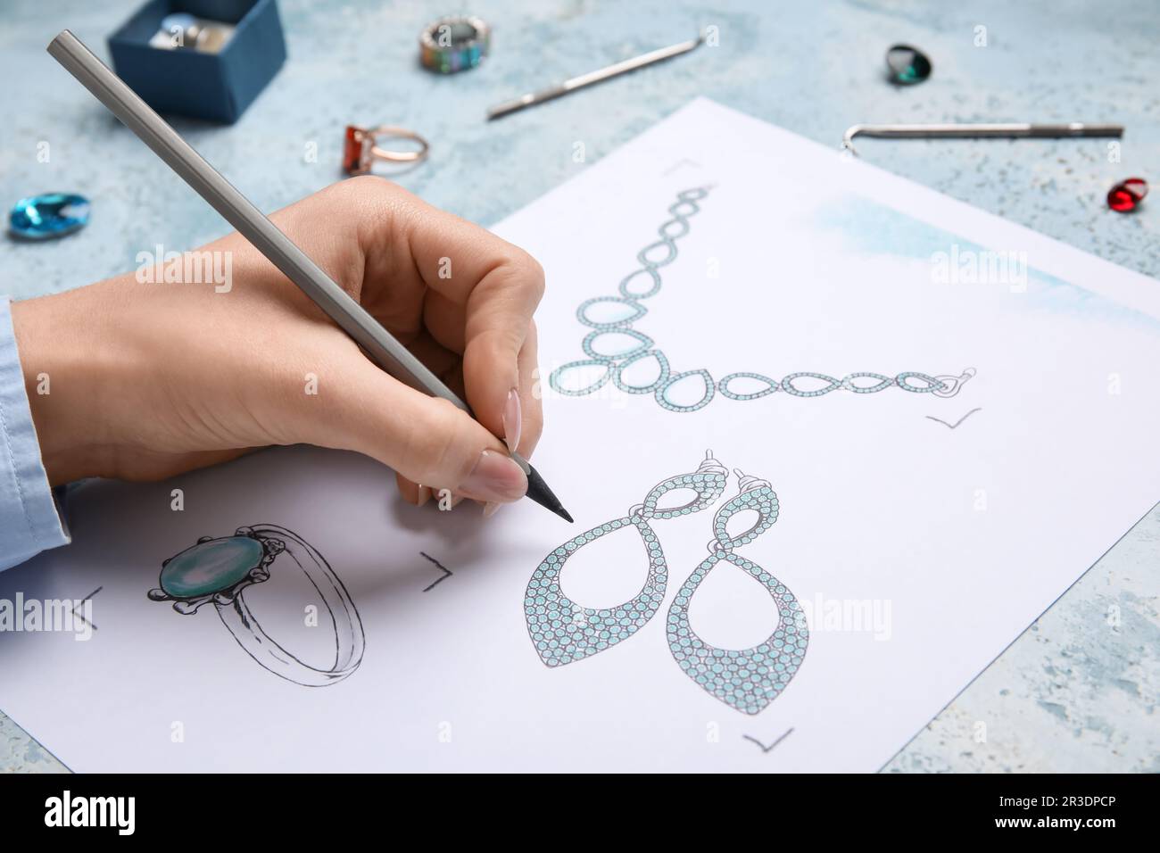 Female jeweler drawing adornment on grunge table, closeup Stock Photo ...
