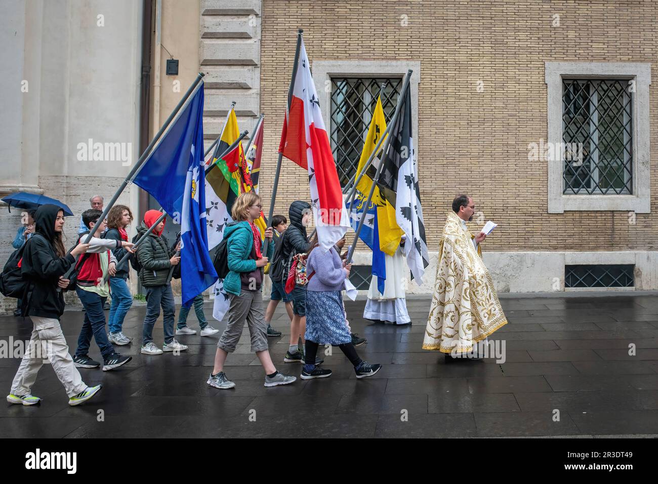The priest in his habit full of golden ornaments seen followed by young ...