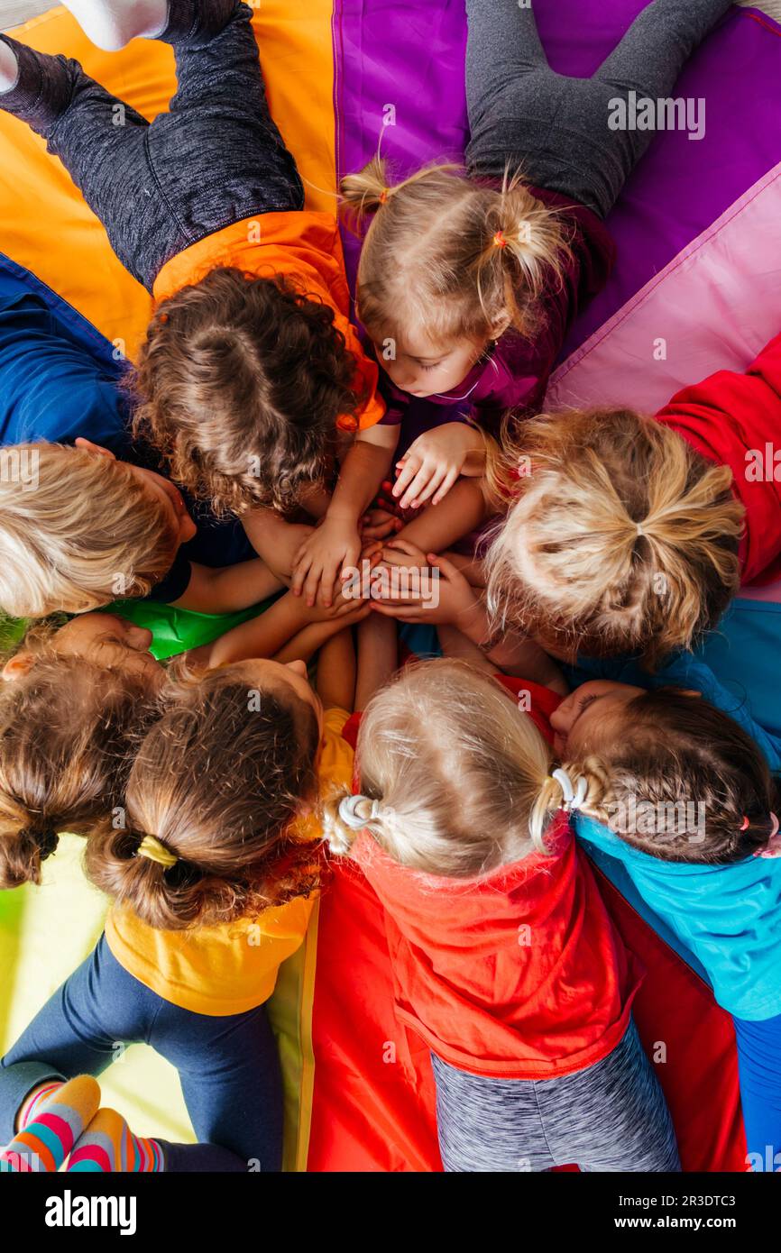 Cheerful children playing team building games on a floor Stock Photo ...