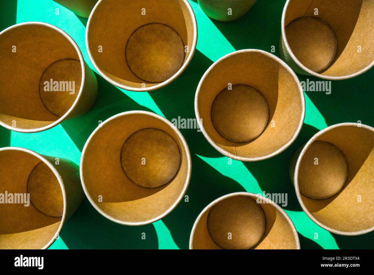 Empty recyclable paper cups on green background. Many takeaway cups for ...