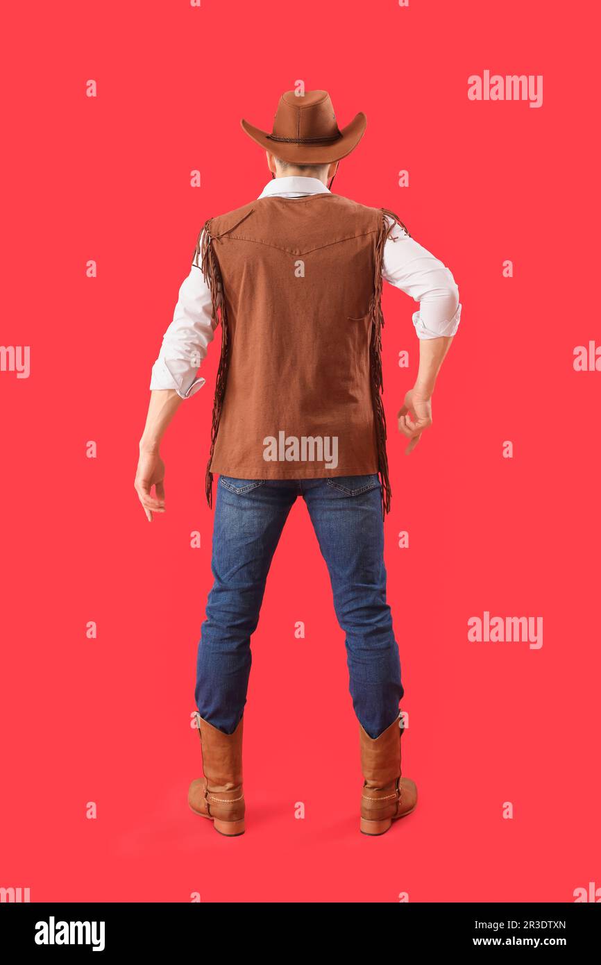 Handsome cowboy on red background, back view Stock Photo - Alamy
