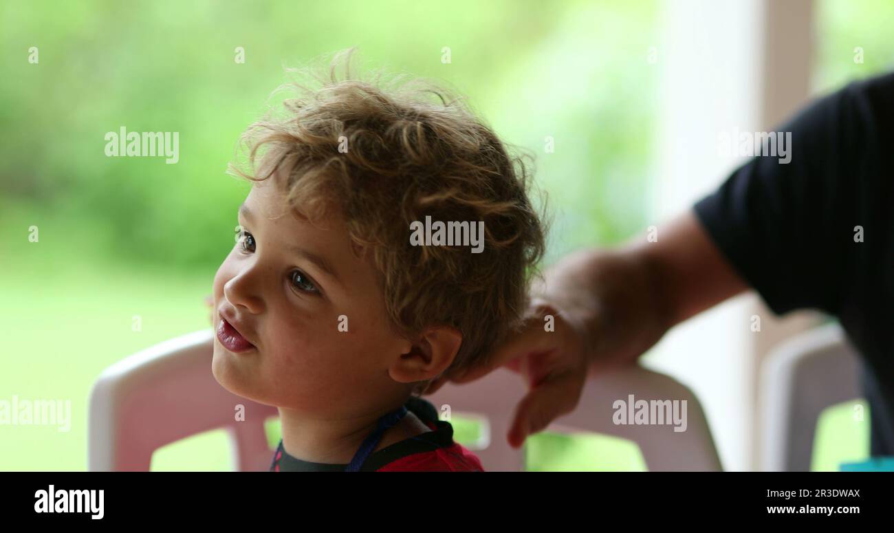 Father rubbing child son hair with hand. Candid casual family moment ...