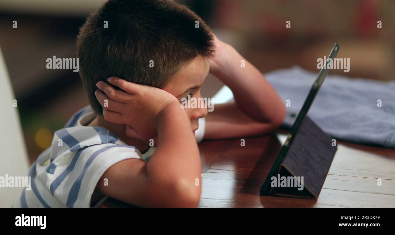 Kid watching movie on tablet. Child absorbed hypnotized by content ...