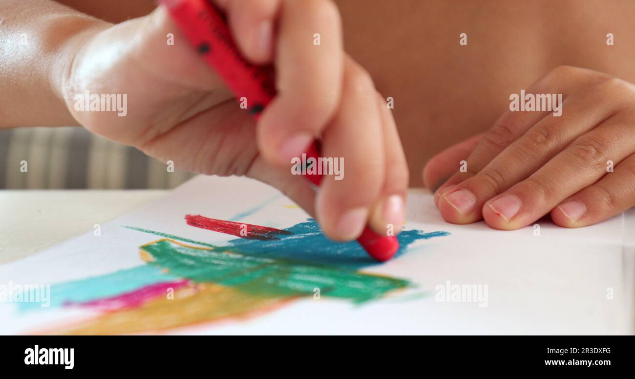 Closeup child hands drawing on paper with crayon Stock Photo - Alamy