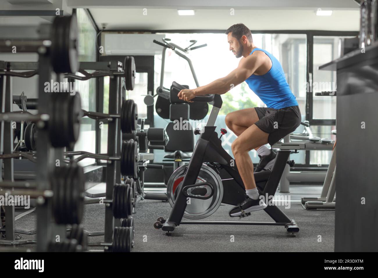 Fit man cycling on a stationary bicycle at the gym Stock Photo - Alamy
