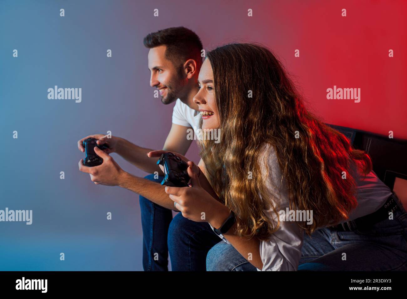 Happy friends holding joysticks and start virtual game Stock Photo - Alamy