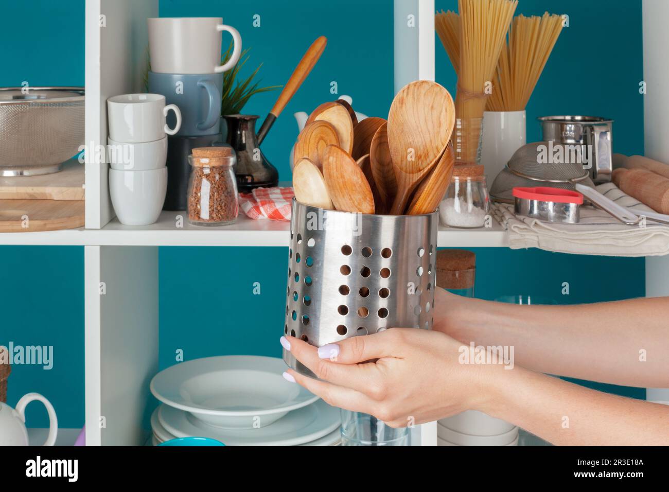 Hand of a woman taking kitchenware from a kitchen shelf Stock Photo - Alamy