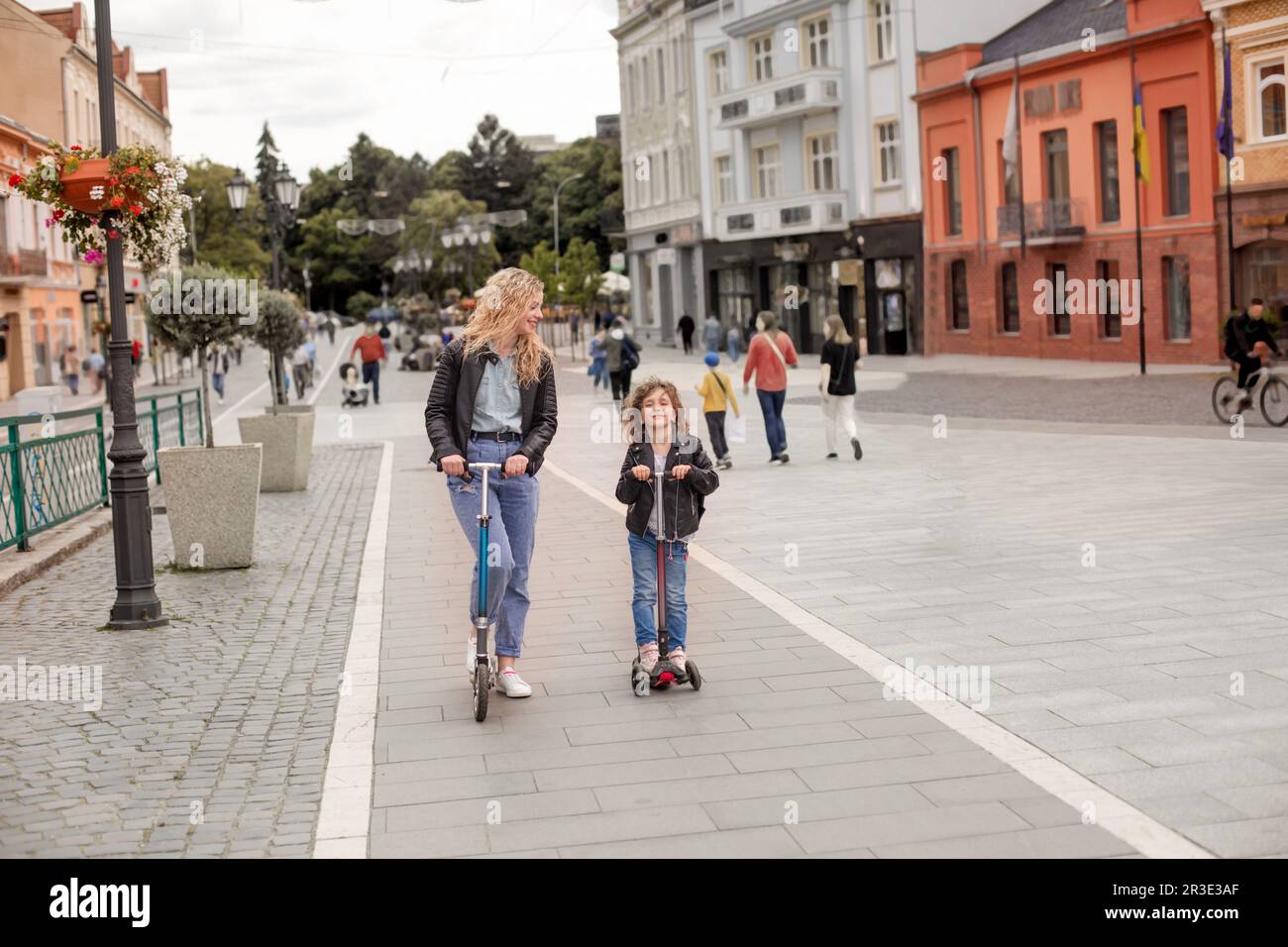 The mom and daughter have fun riding scooters Stock Photo - Alamy