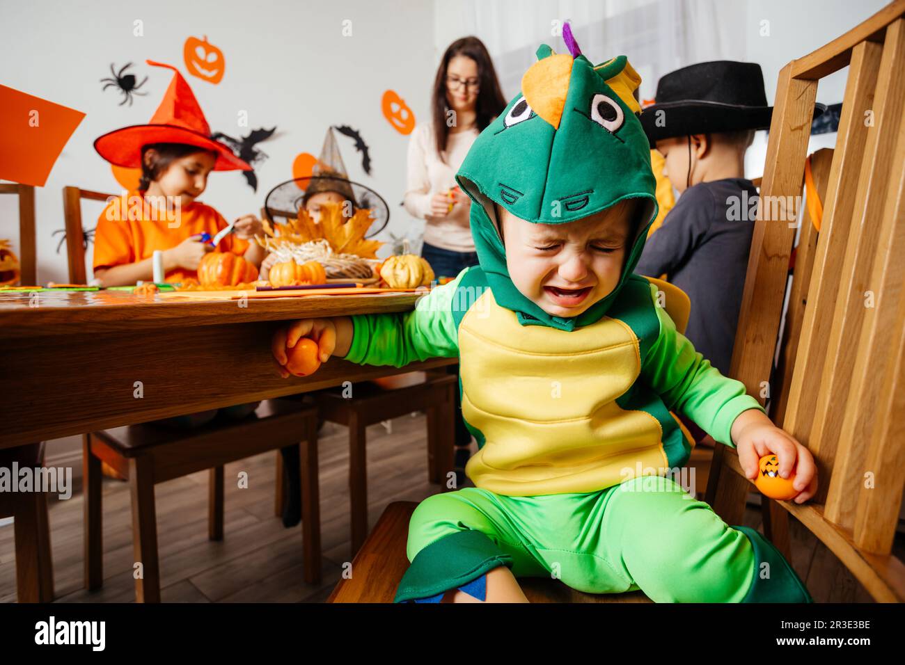 Little baby boy in green fancy costume sitting and crying Stock Photo ...