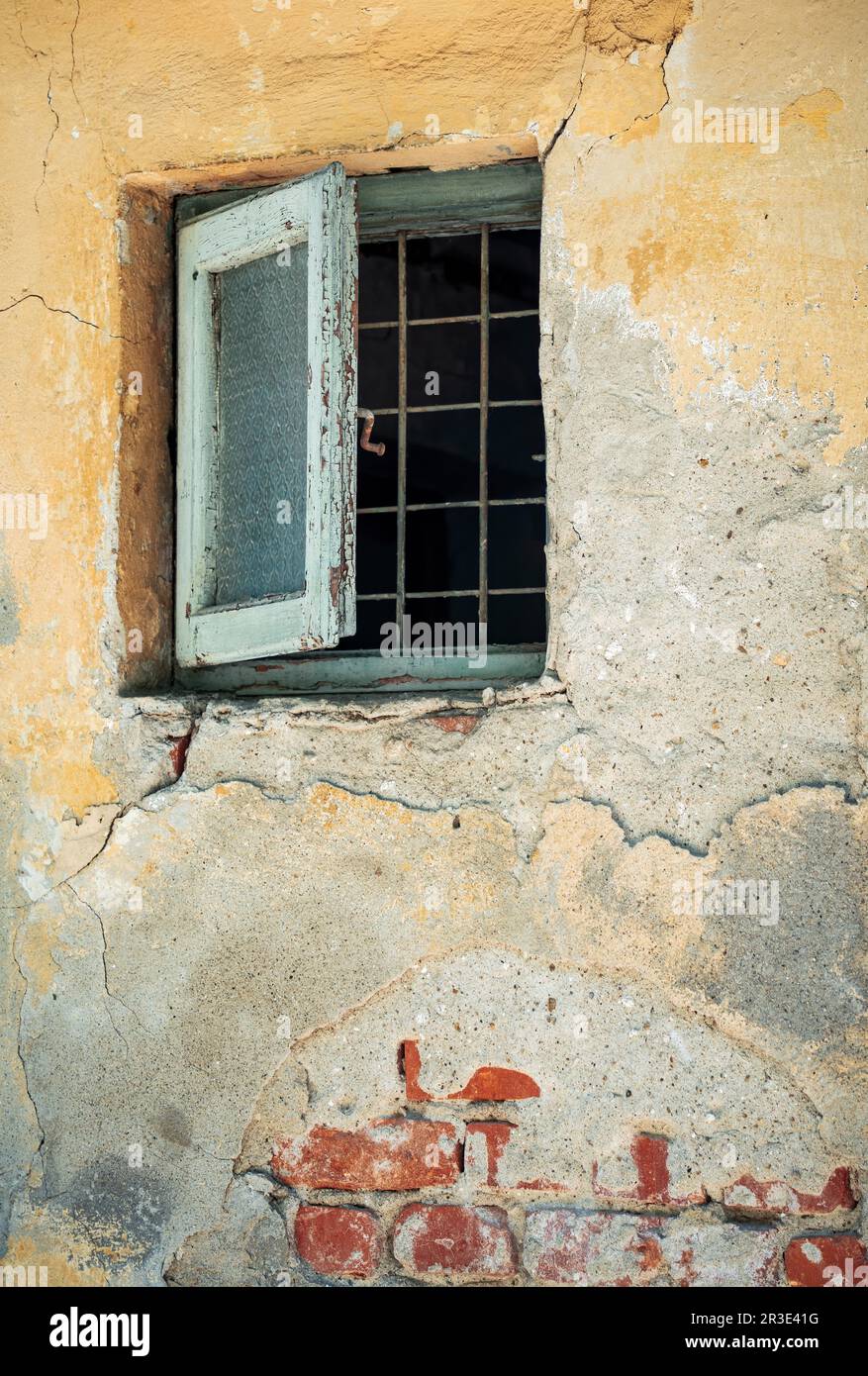 Small wooden barred window. Vintage picture with the worn out old brick ...