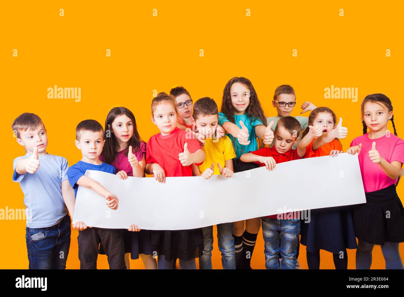 The group of kids holding a big white copy space poster Stock Photo - Alamy