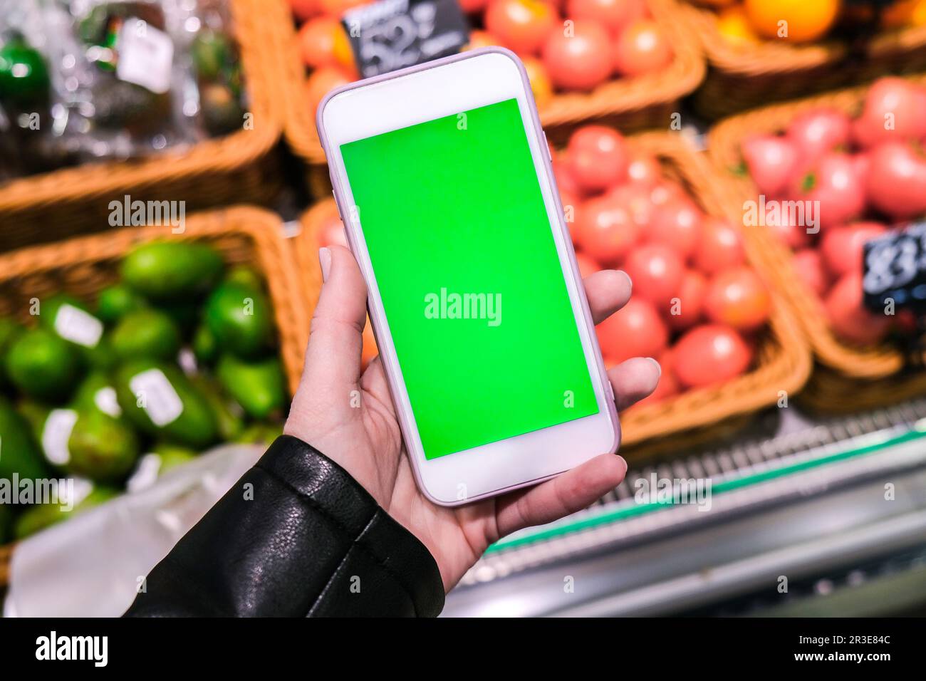 Chroma key. Close up of woman holds smart phone with green screen at ...