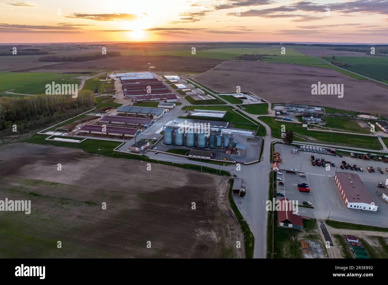 aerial panoramic view over silos and rows of barns, pigsties, chicken ...