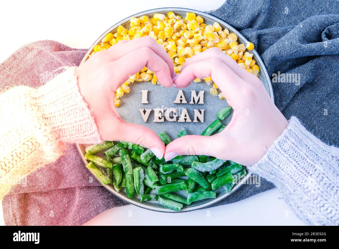 Female hands in shape of heart love I AM VEGAN text in plate. Veganism ...