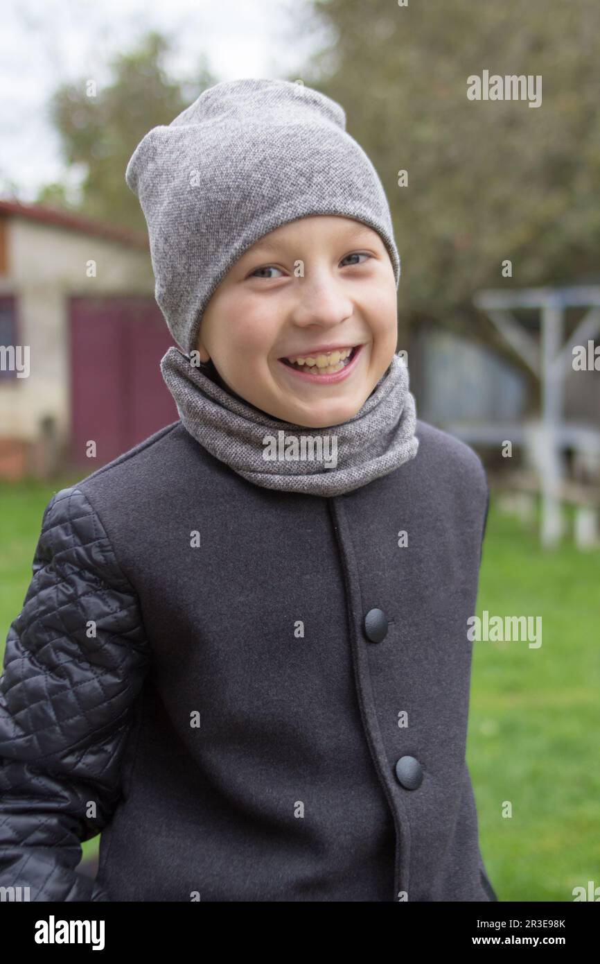 funny boy in the autumn clothes laughs, gray coat with Stock Photo - Alamy