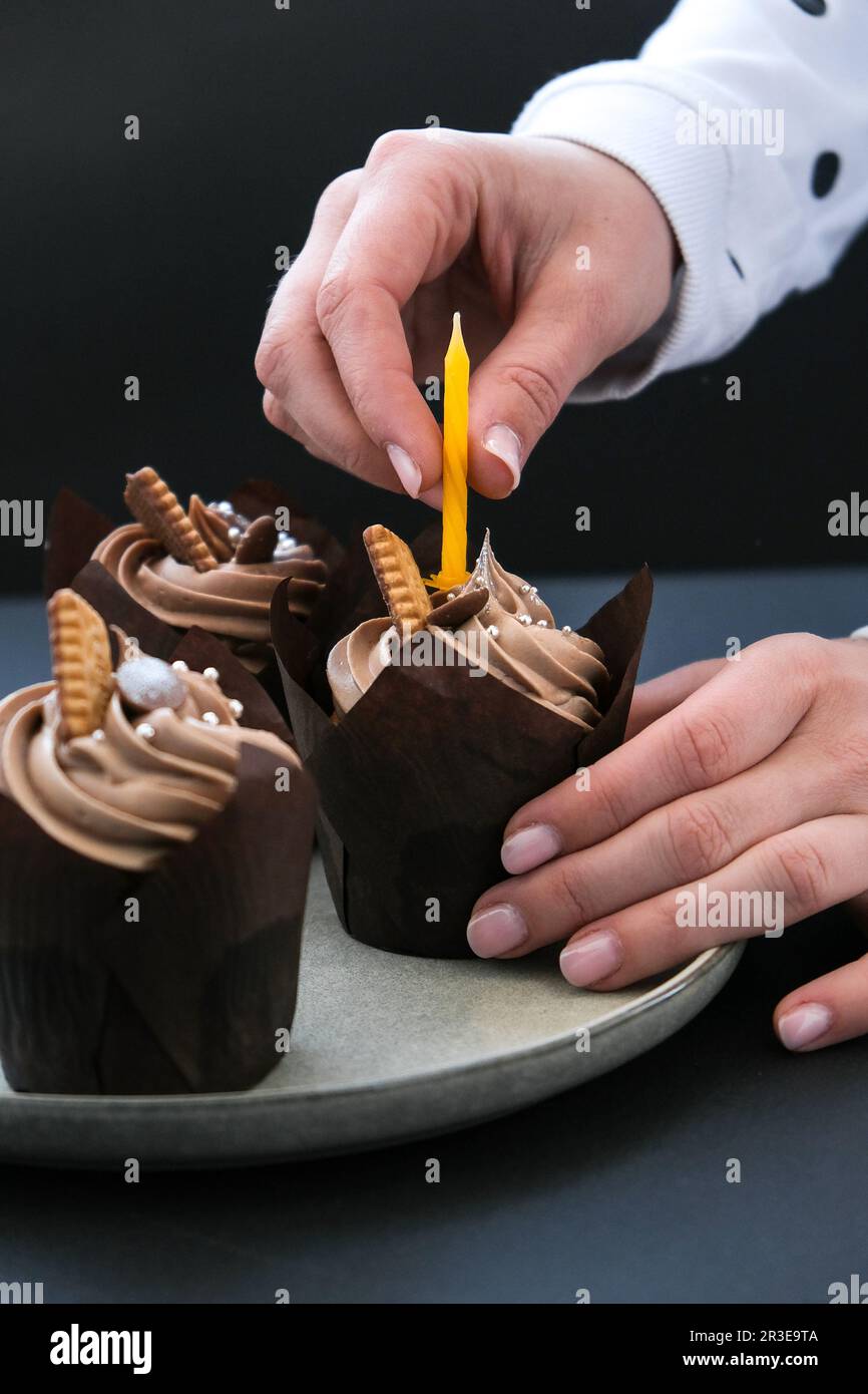 Female hands making Delicious chocolate cupcakes with cream on dark ...