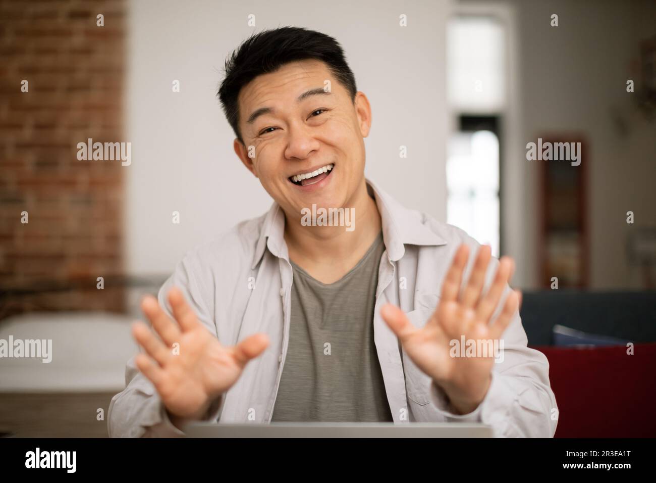 Cheerful korean man having virtual online meeting and emotional ...