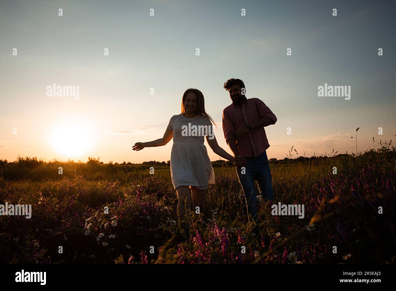 Lovely couple walking in the summer field Stock Photo - Alamy