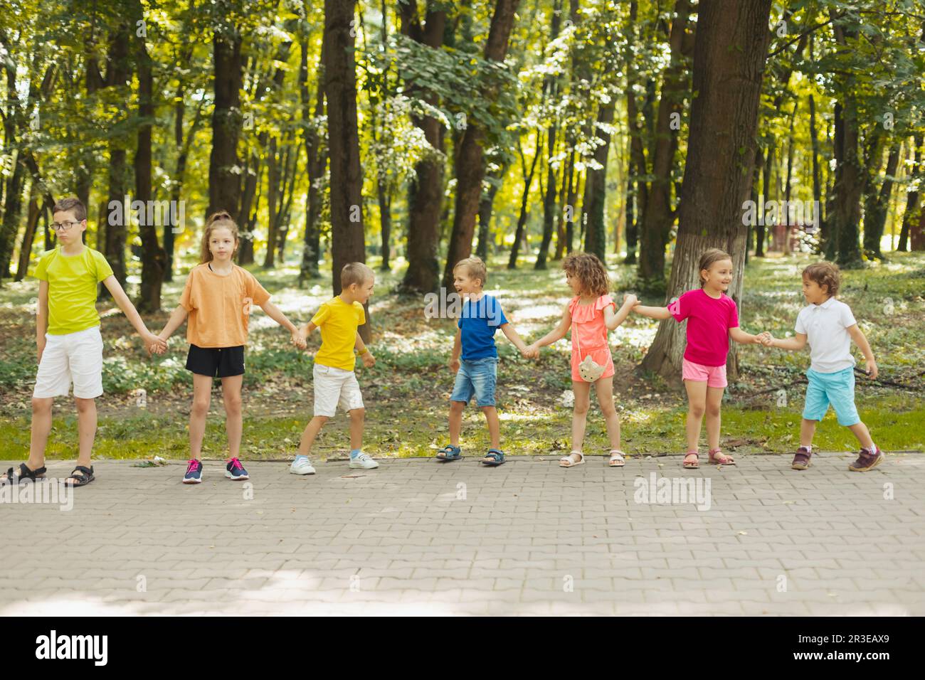 Summer camp kids making wave, holding hands together Stock Photo - Alamy