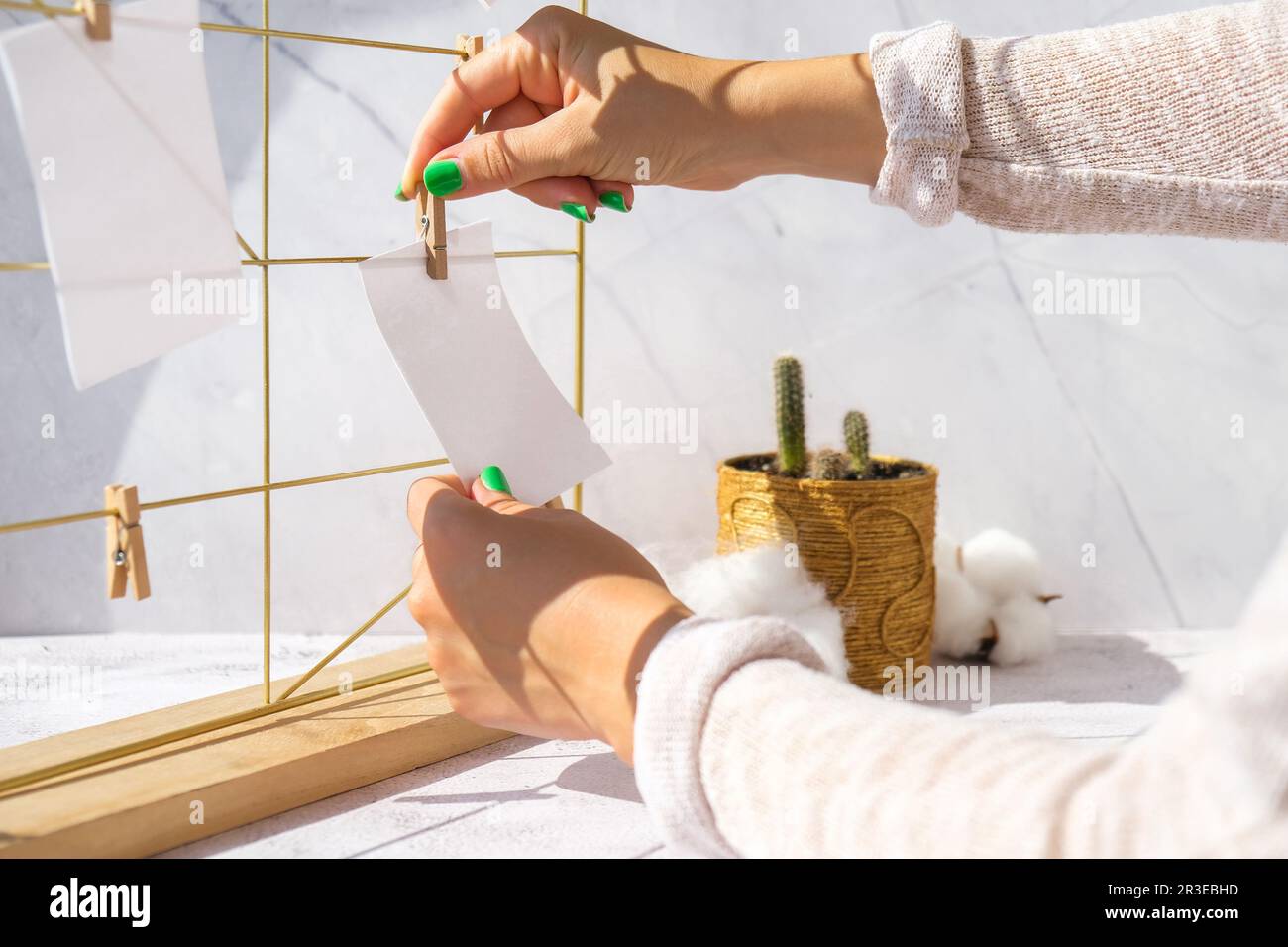 Woman creating mood board. Cards and posters mock ups on grid board ...