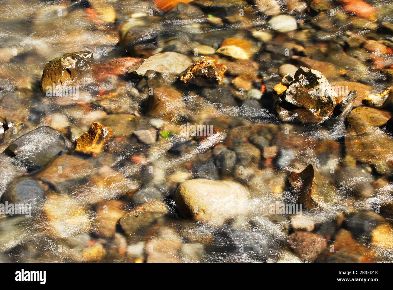 Rocks in a stream with reflections Stock Photo - Alamy